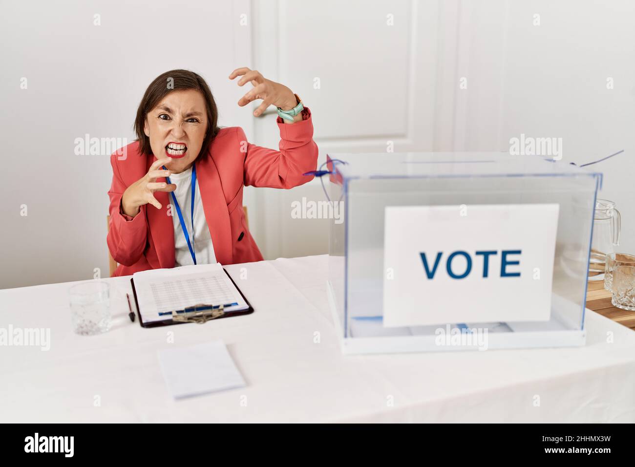 Beautiful middle age hispanic woman at political election sitting by ...