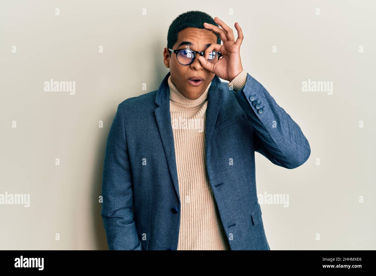 Young handsome hispanic man wearing elegant clothes and glasses doing ...
