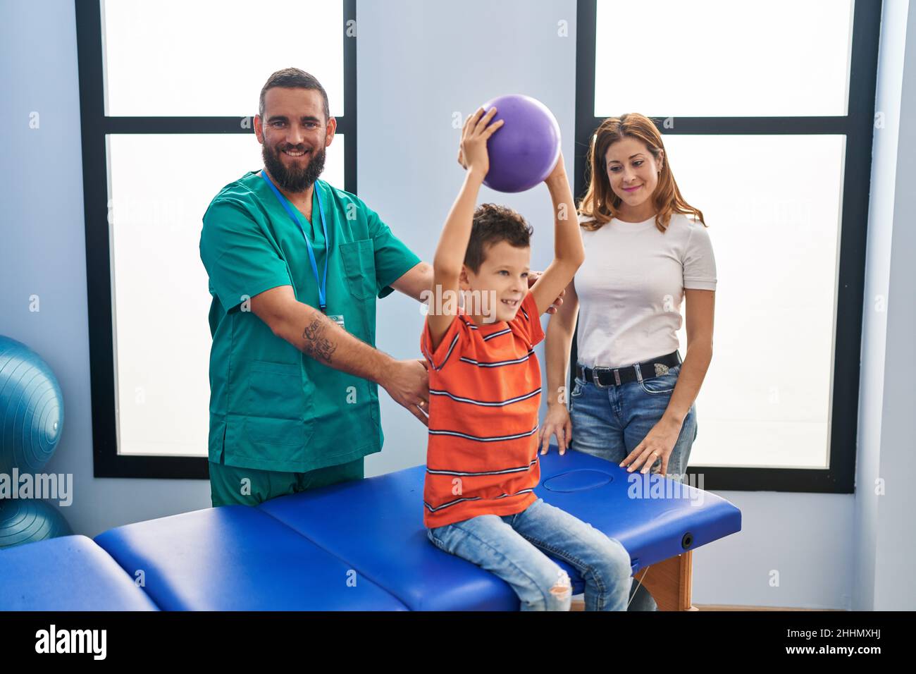Family having rehab session using ball at rehab clinic Stock Photo - Alamy