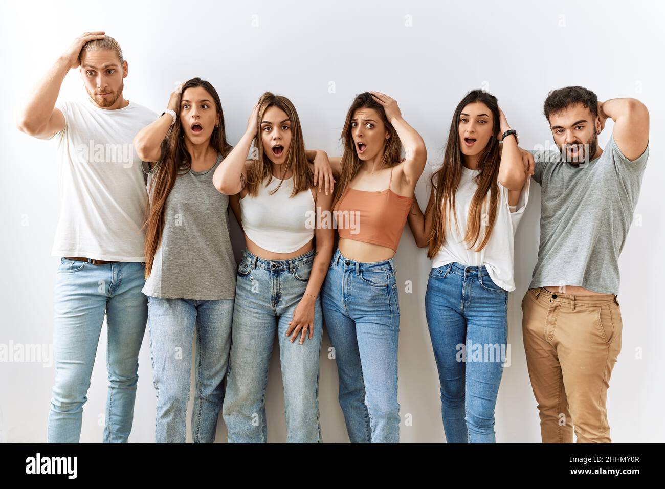 Group of young friends standing together over isolated background crazy ...