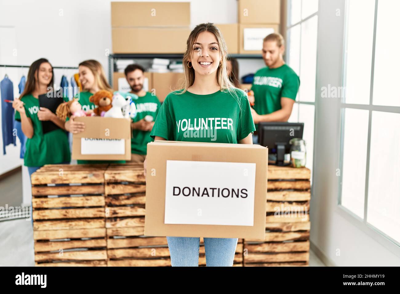 Group of young volunteers working at charity center. Man smiling happy ...
