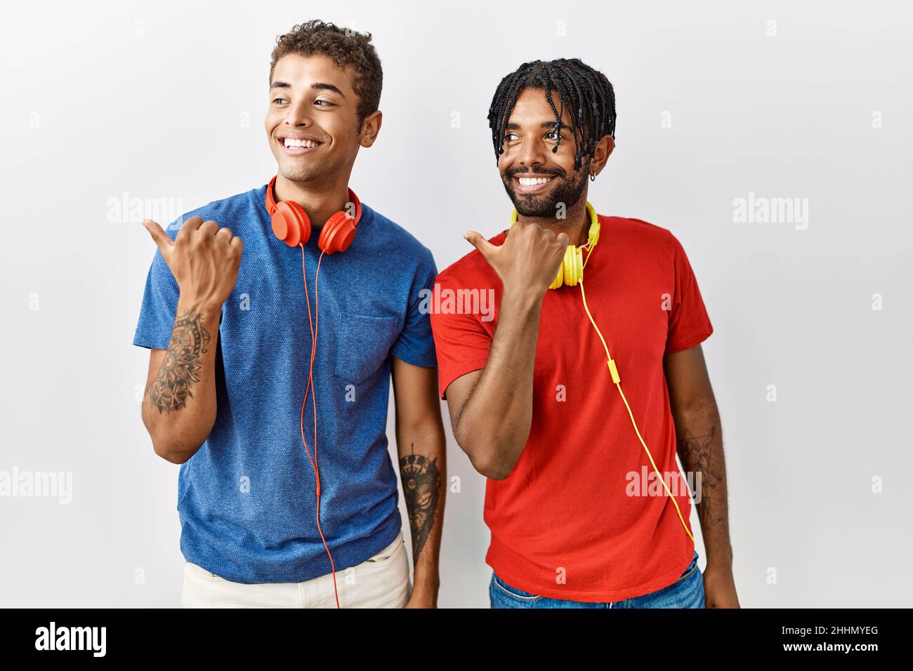 Young hispanic brothers standing over isolated background wearing ...