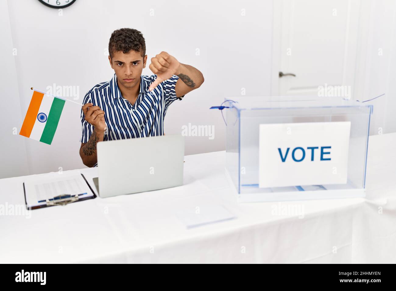 Young handsome hispanic man at political campaign election holding ...