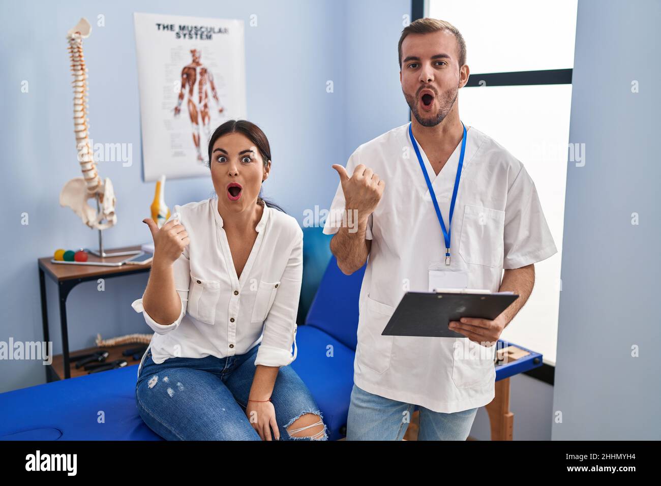 Young hispanic woman at physiotherapist appointment surprised pointing ...
