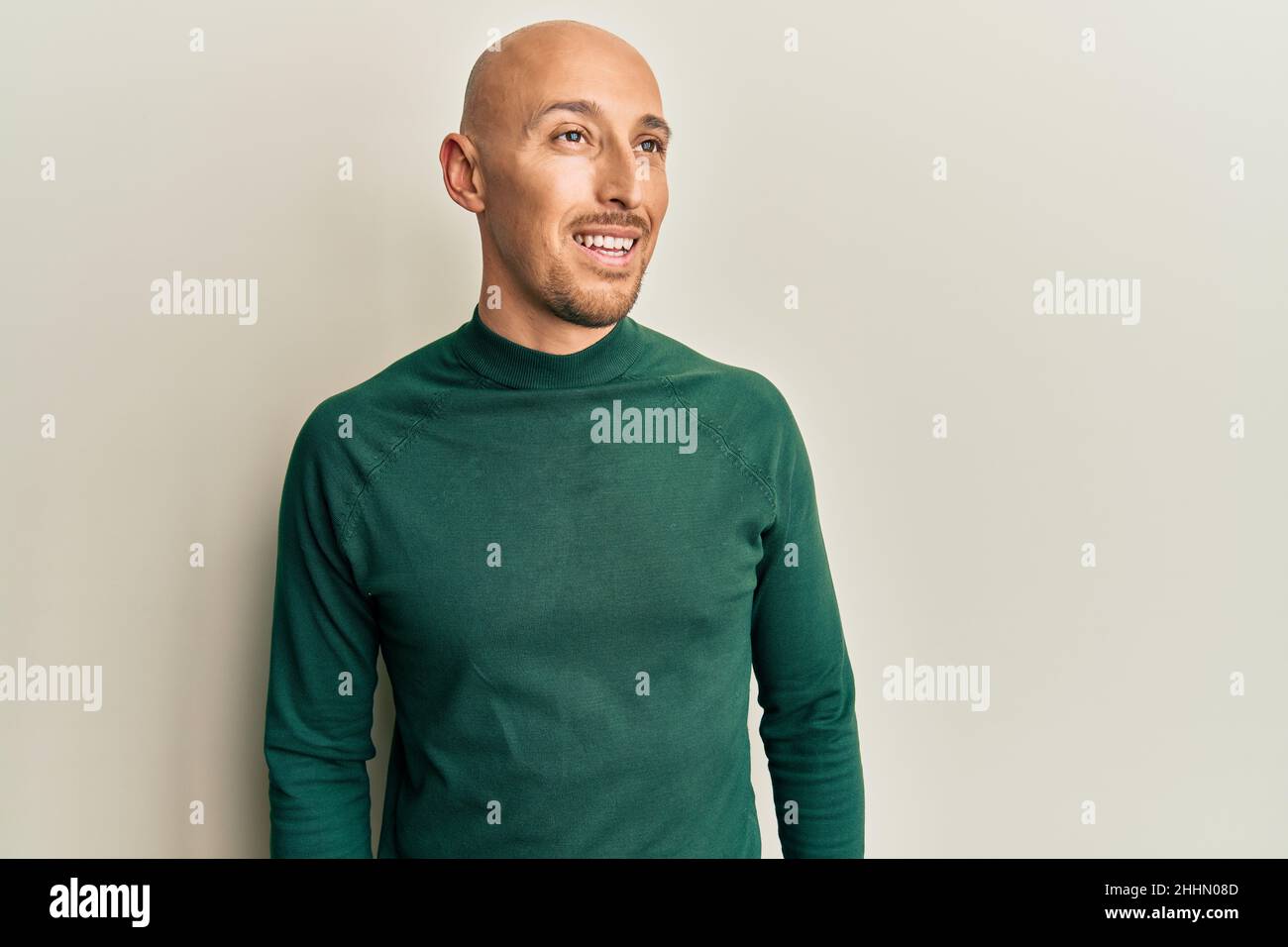 Bald man with beard wearing casual turtleneck sweater looking to side ...