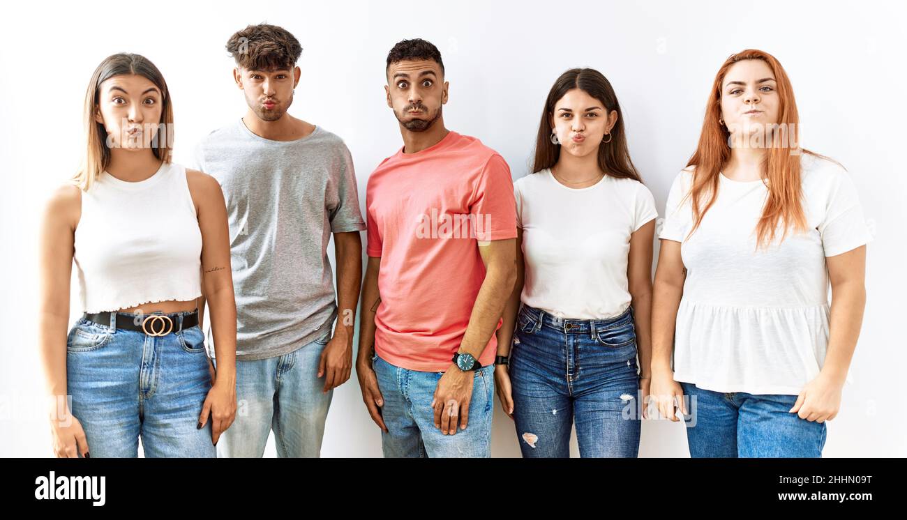 Group of young friends standing together over isolated background ...