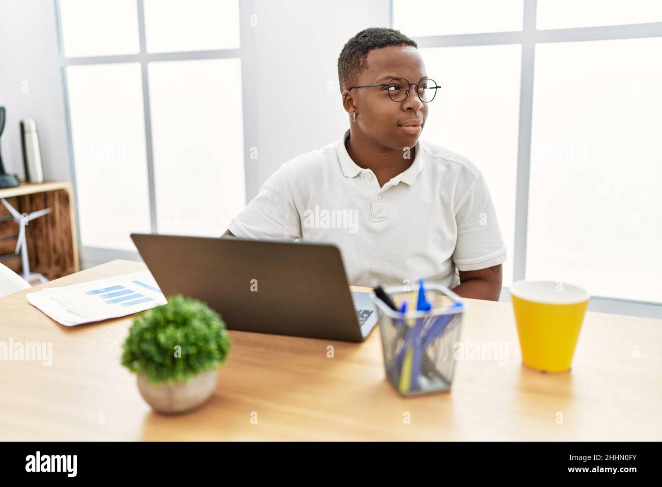 Young african man working at the office using computer laptop looking ...