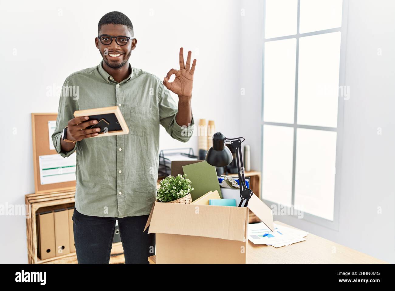 Young african american businessman unboxing box at the office smiling ...