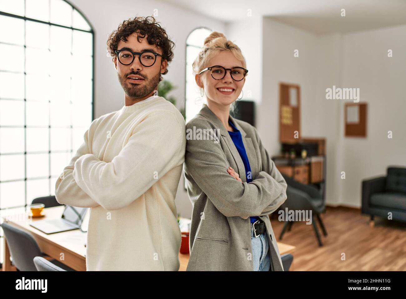 Two business workers smiling happy standing with arms crossed gesture ...