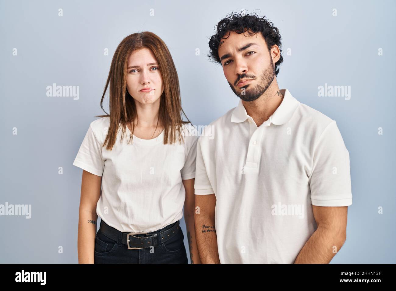 Young couple wearing casual clothes standing together depressed and ...
