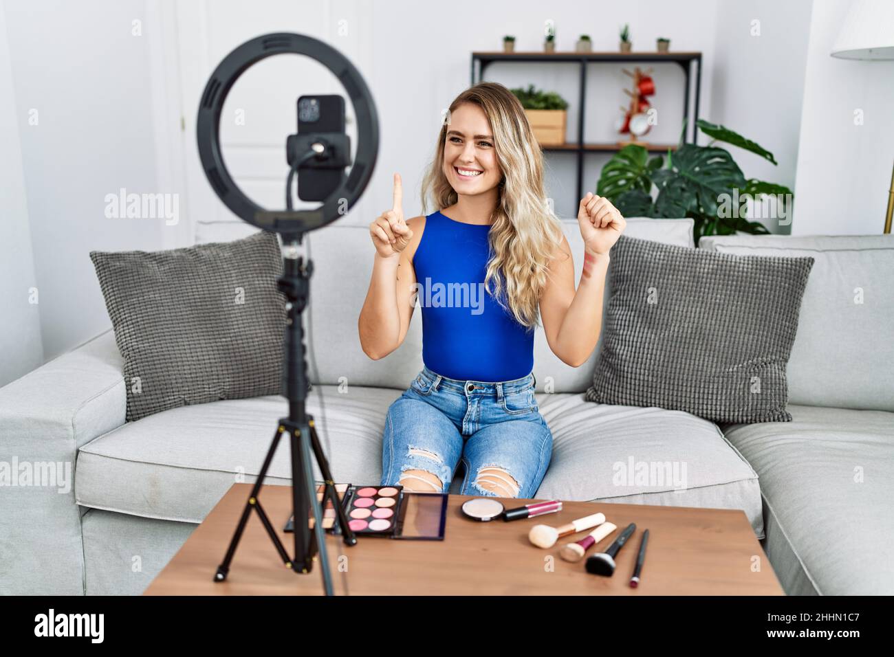 Young beautiful woman recording make up vlog tutorial with smartphone ...