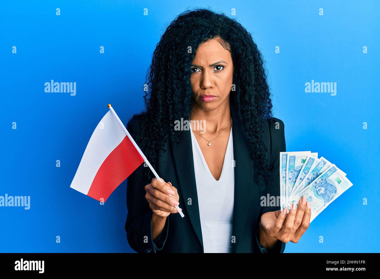 Middle age african american woman holding poland flag and zloty ...