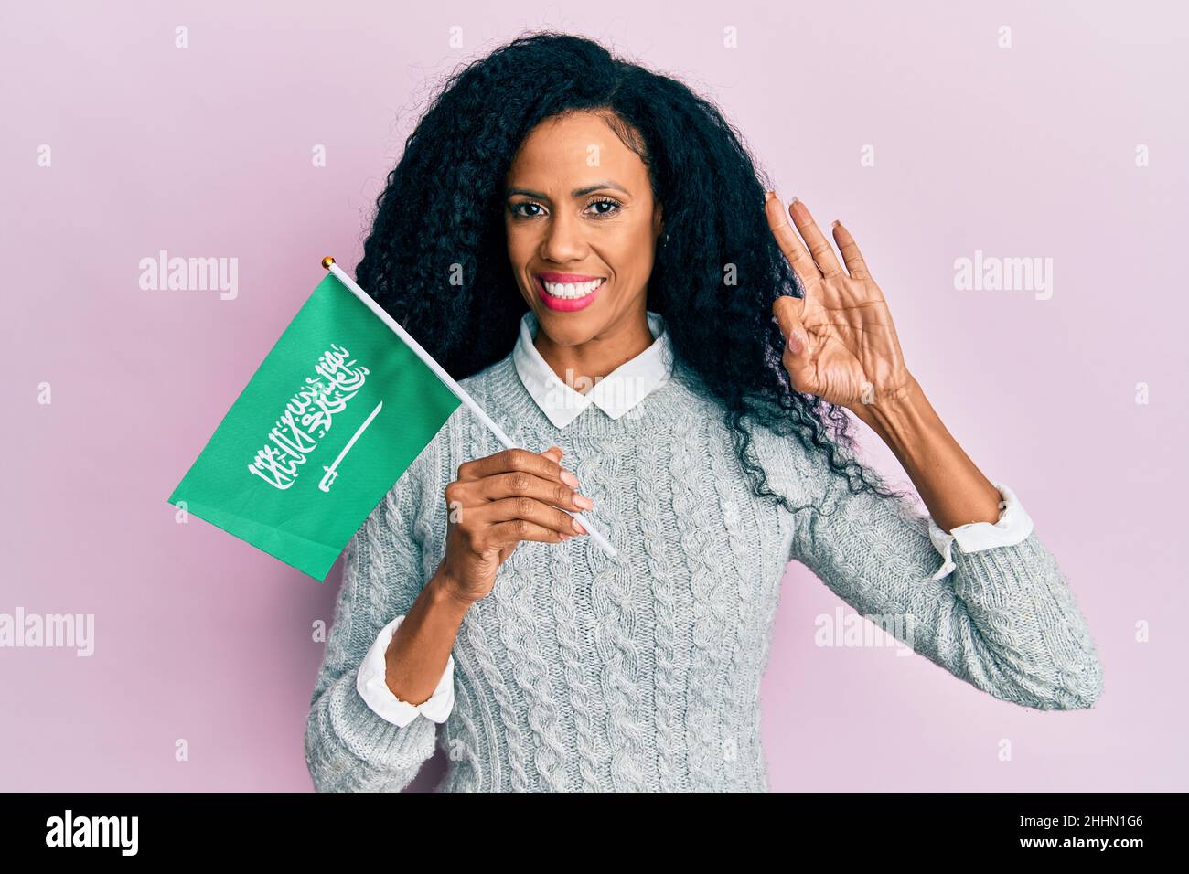 Middle age african american woman holding kingdom of saudi arabia flag ...