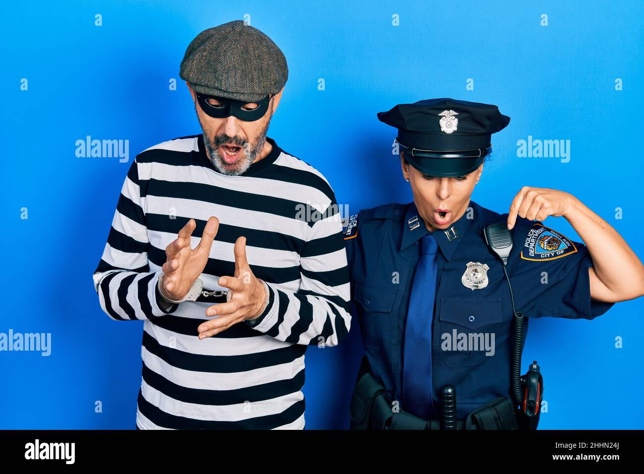 Middle age couple of hispanic woman and man wearing thief and police ...