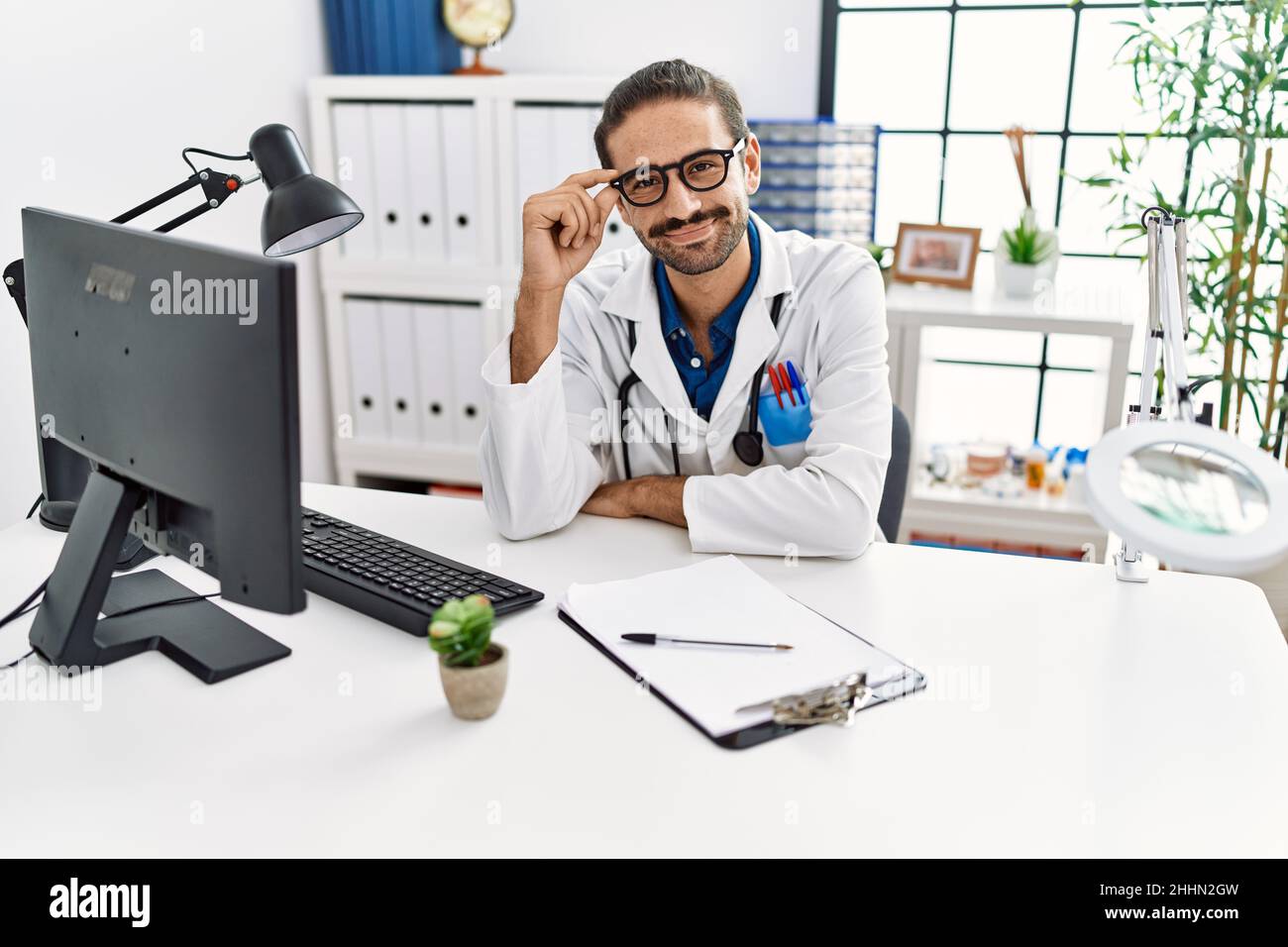 Handsome hispanic man working as doctor at hospital clinic Stock Photo ...