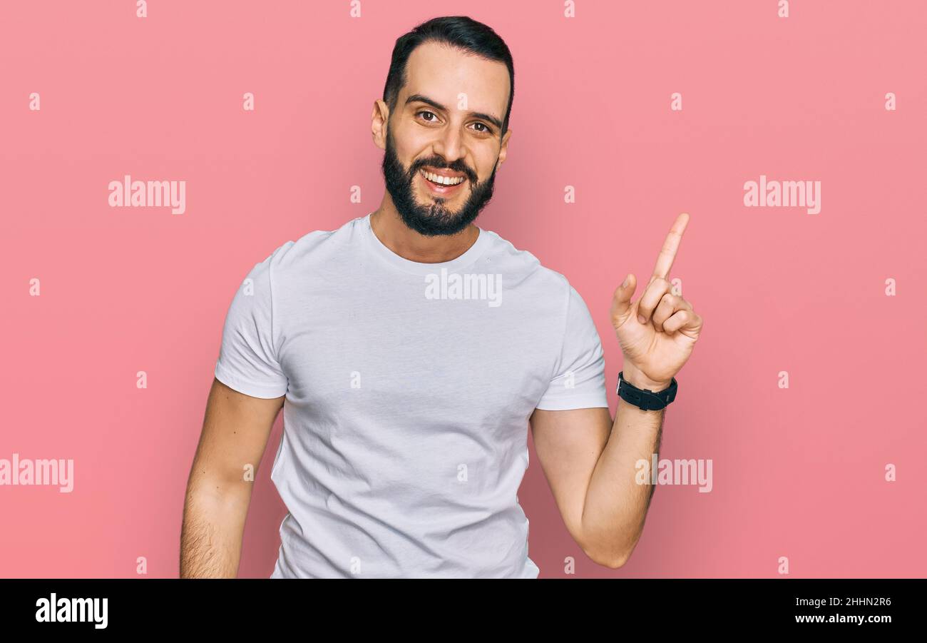 Young man with beard wearing casual white t shirt with a big smile on ...