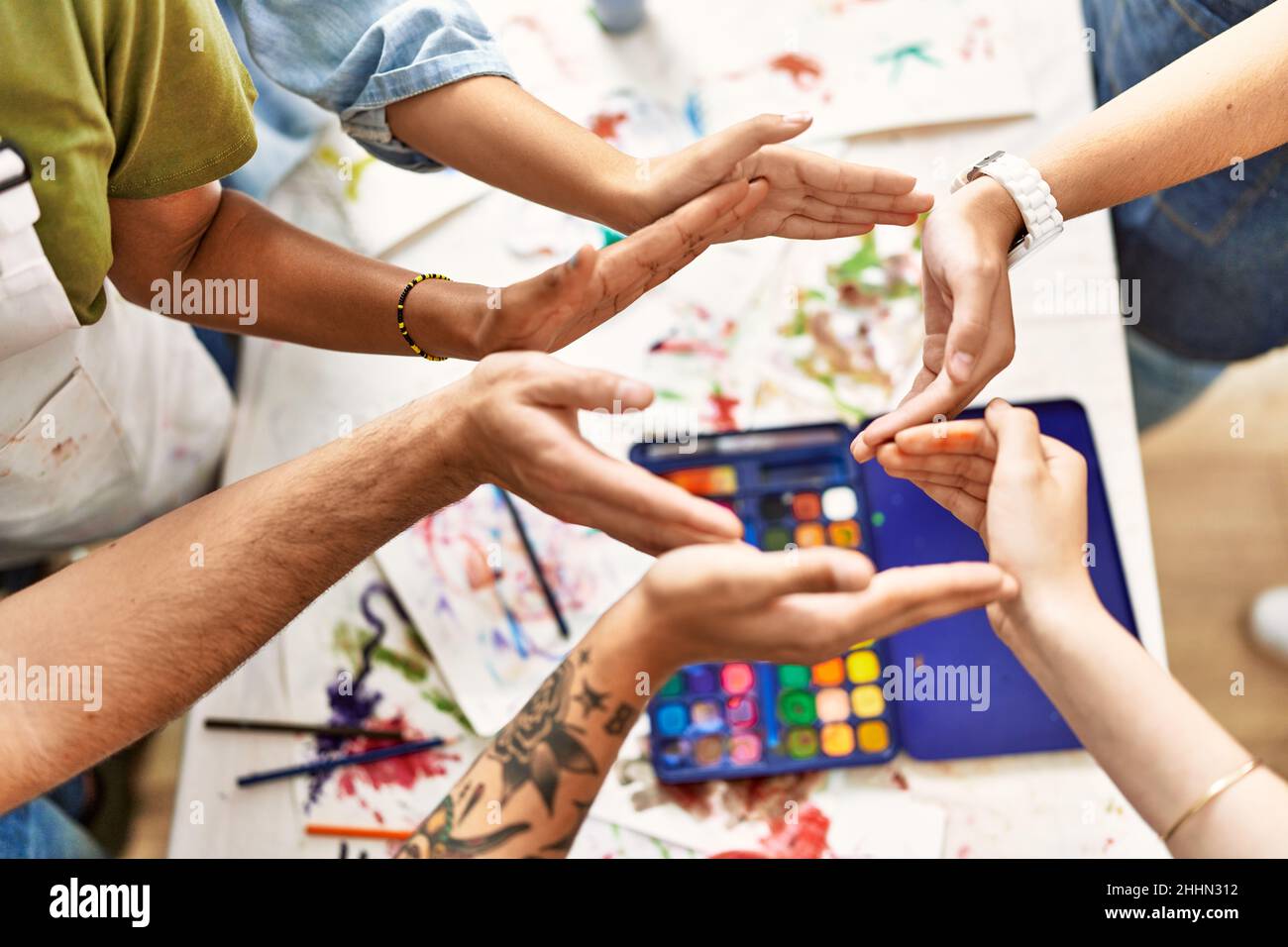 Group of people doing heart sign with hands together at art studio ...