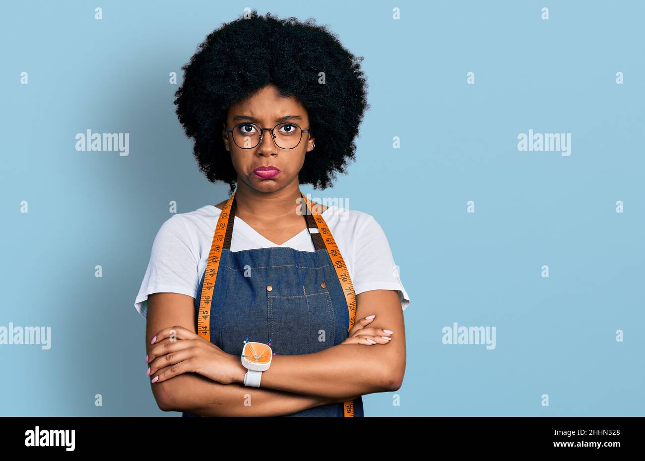 Young african american woman dressmaker designer wearing atelier apron depressed and worry for ...