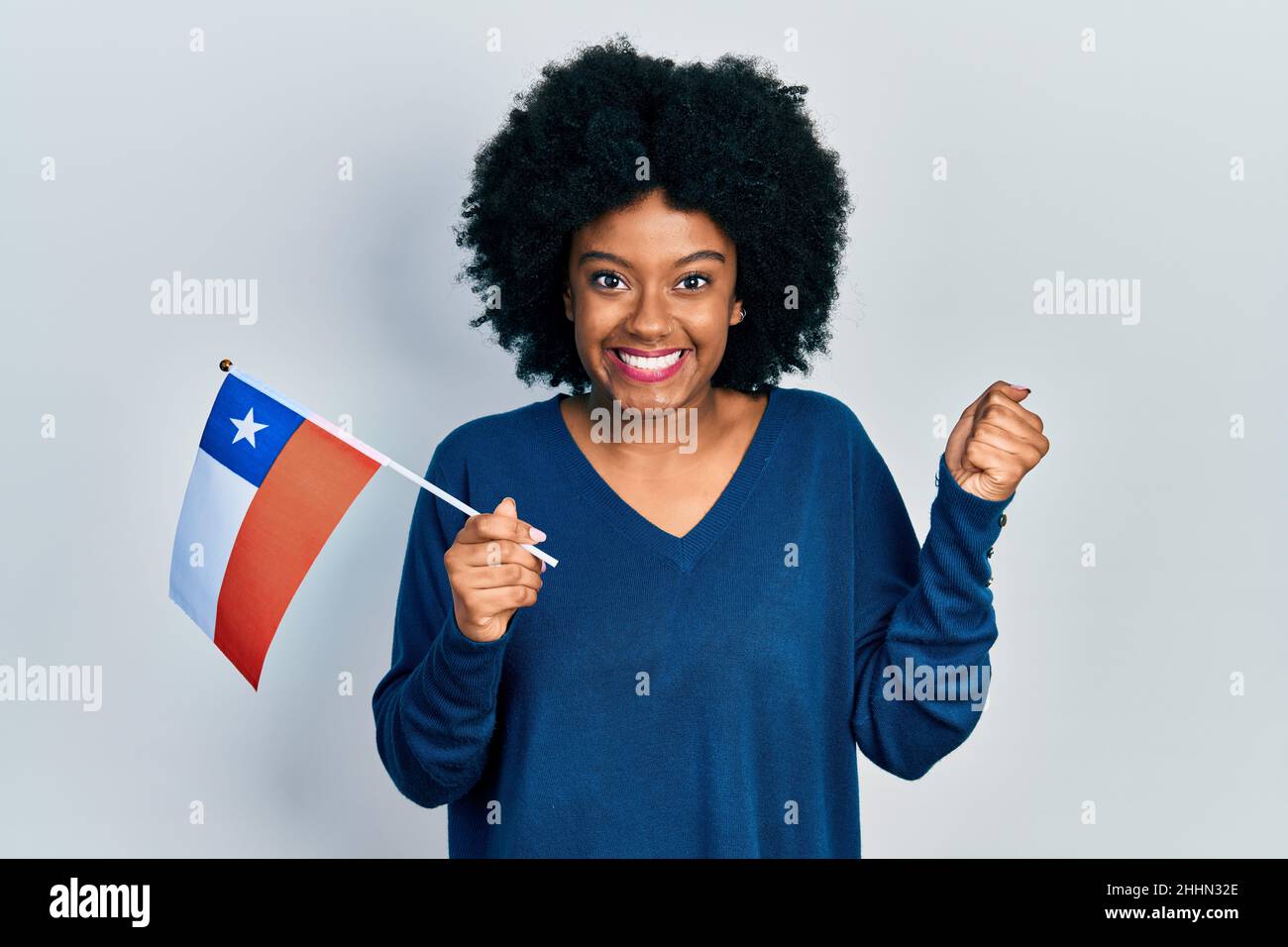 Young african american woman holding chile flag screaming proud ...