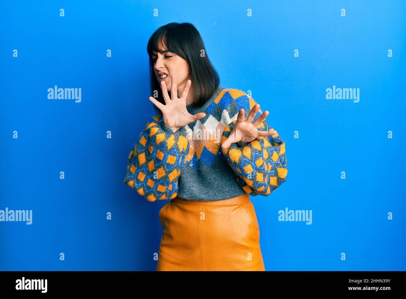 Young hispanic woman wearing casual winter sweater disgusted expression ...