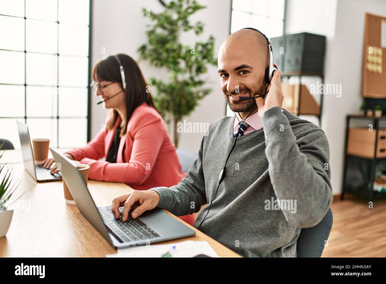 Two call center agent smiling happy working at the office Stock Photo ...
