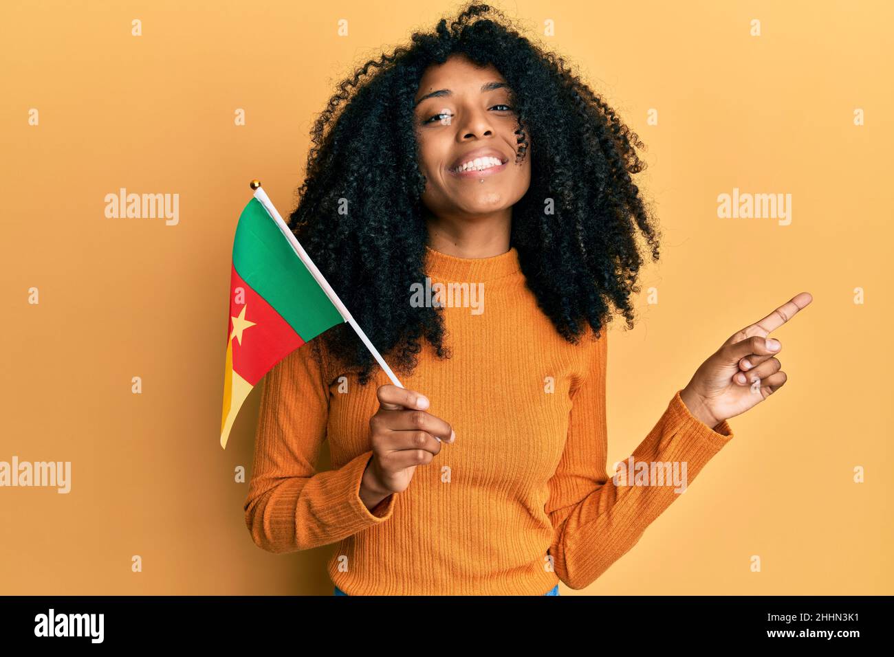 African american woman with afro hair holding senegal flag smiling ...