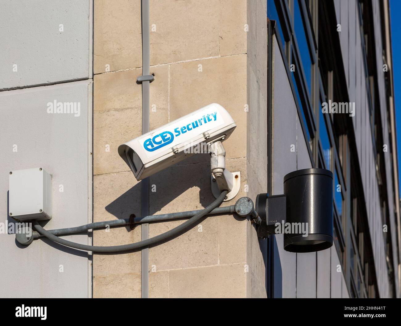 CCTV surveillance camera operated by ACE Security mounted on wall of ...