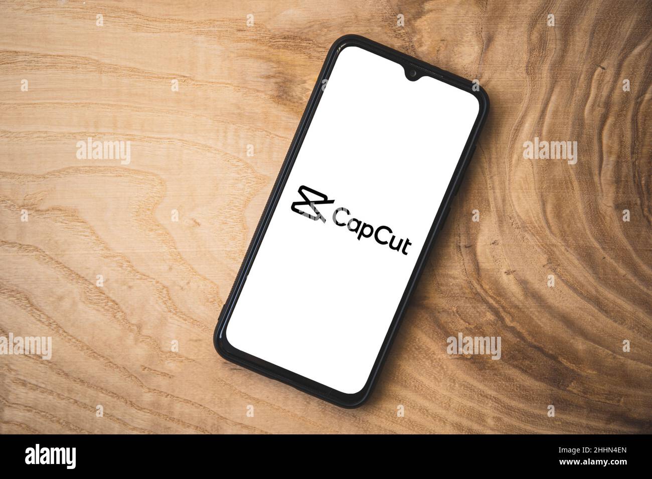 Capcut application on smartphone. Wooden background. Top angle shot ...