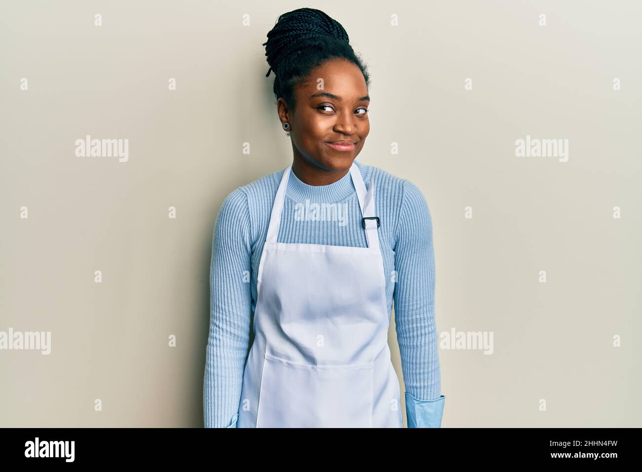 African american woman with braided hair wearing cleaner apron and ...