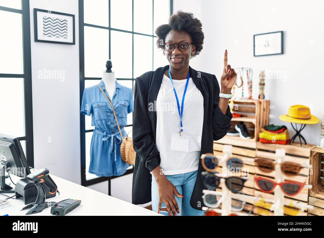 African young woman working as manager at retail boutique showing and ...