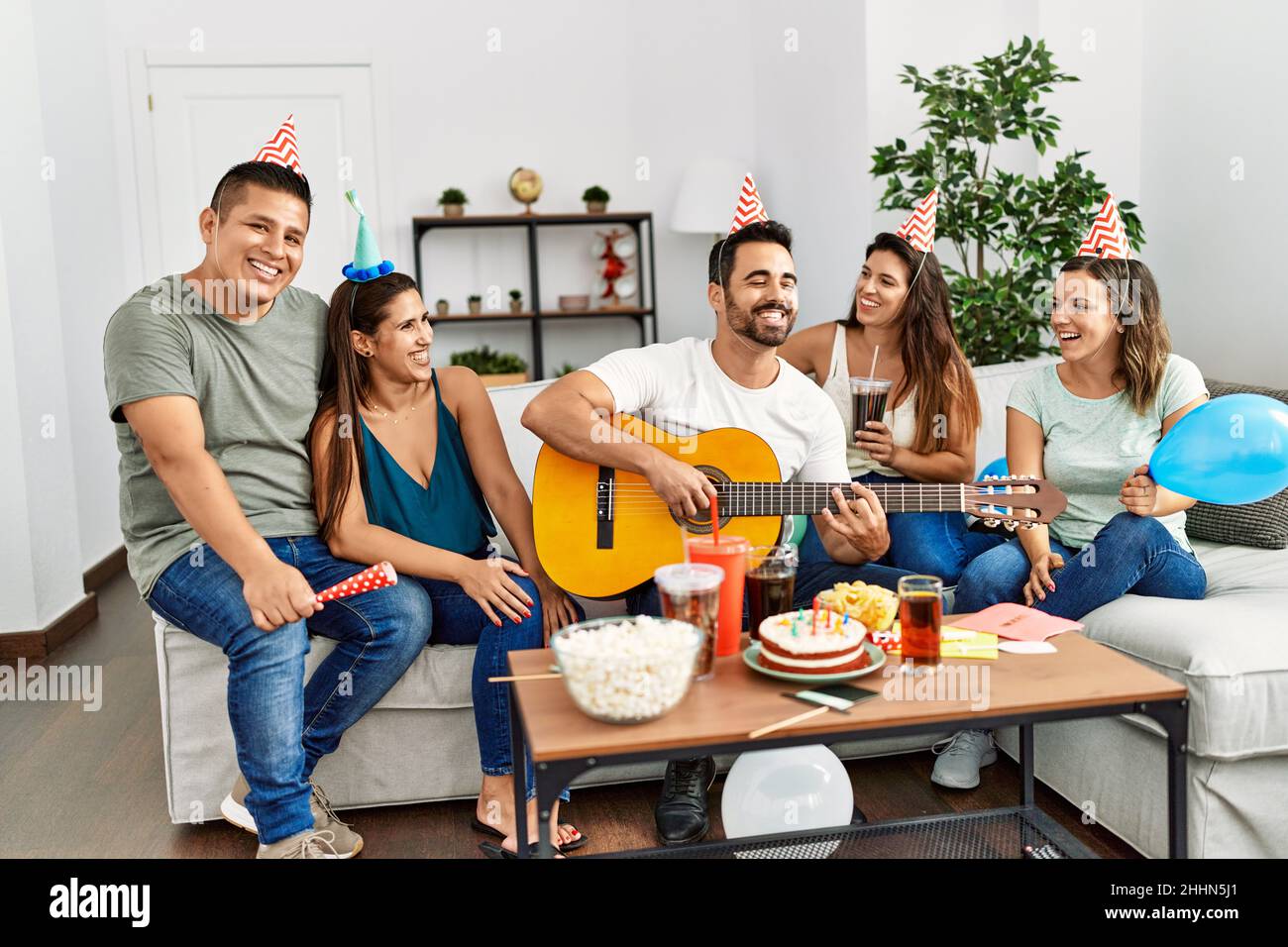 Group of young hispanic friends having birthday party playing spanish ...