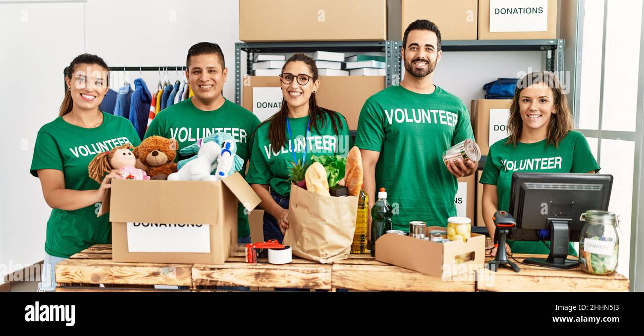 Group of young volunteers smiling happy standing at charity center ...
