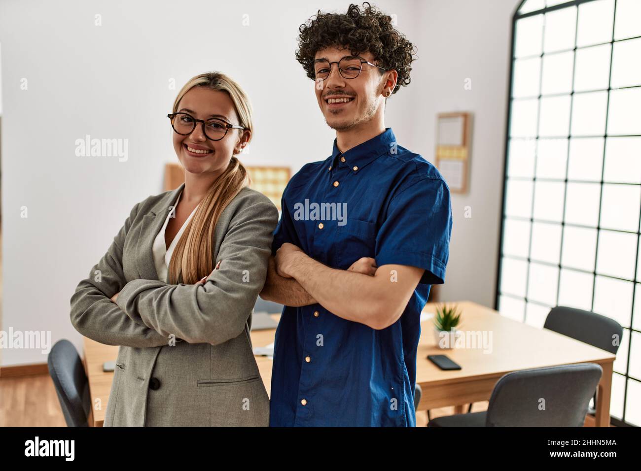 Two business executives with arms crossed gesture standing at the ...