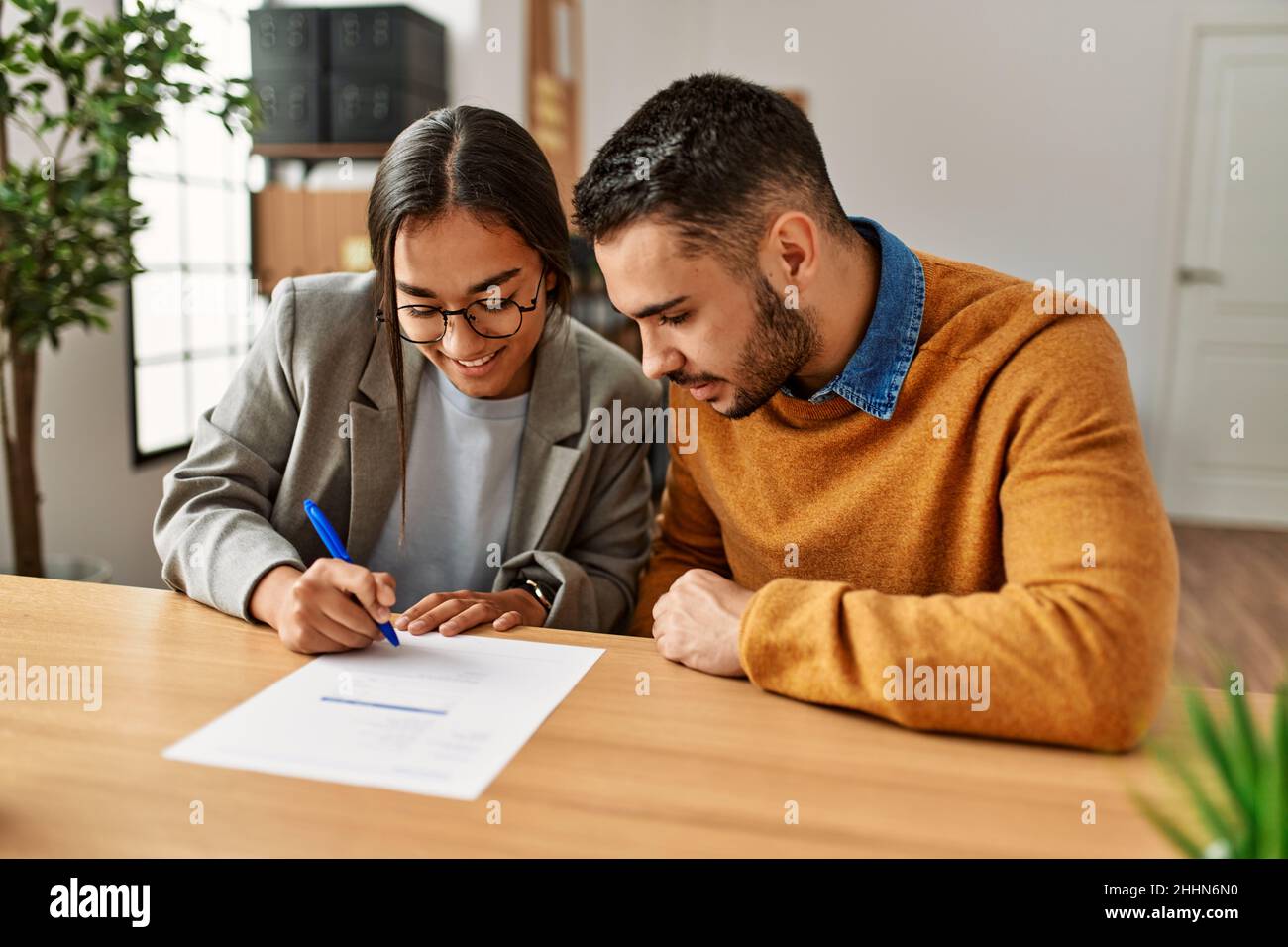 Couple smiling happy reading document at the office Stock Photo - Alamy