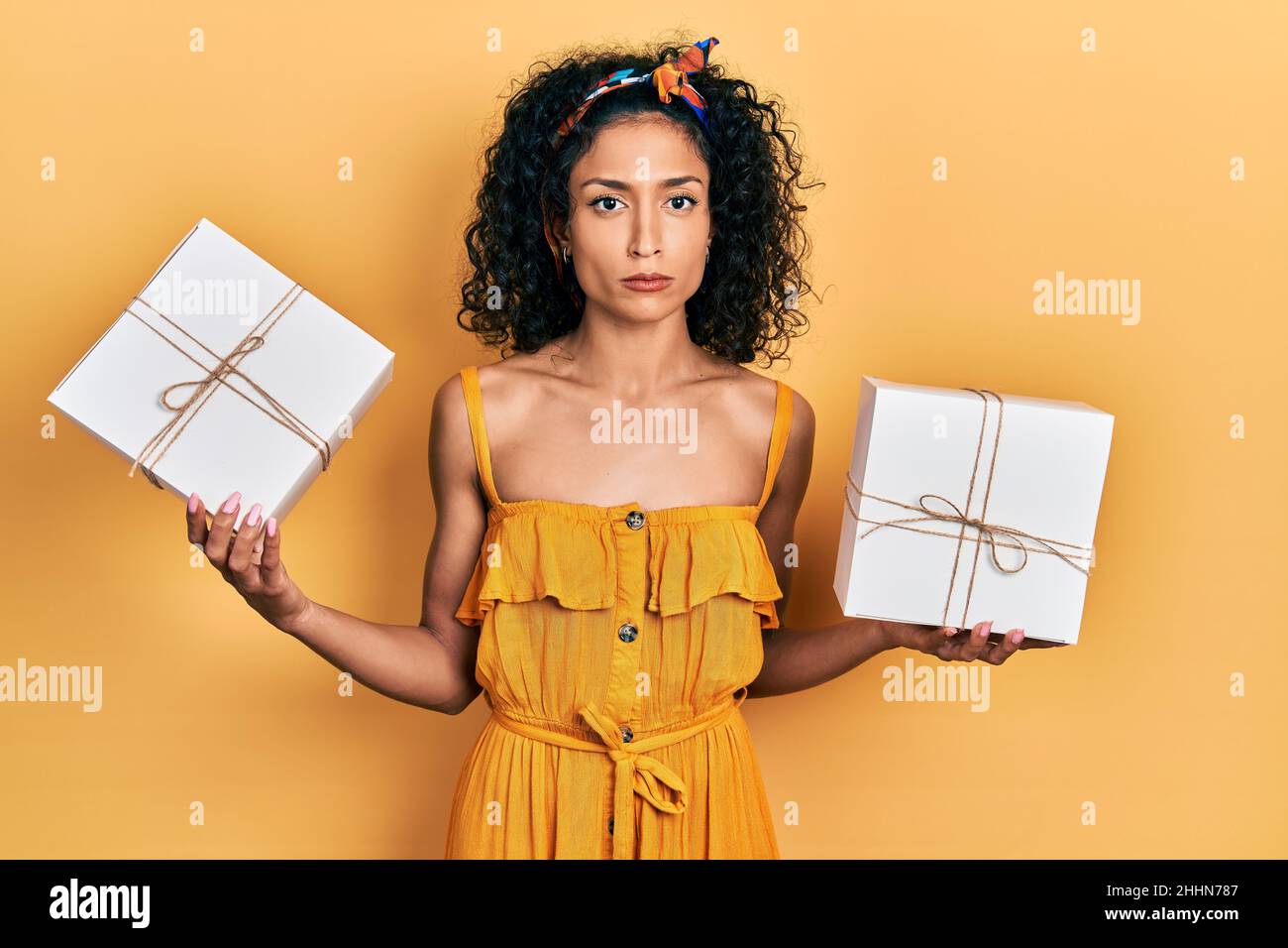 Young latin girl holding gifts depressed and worry for distress, crying ...