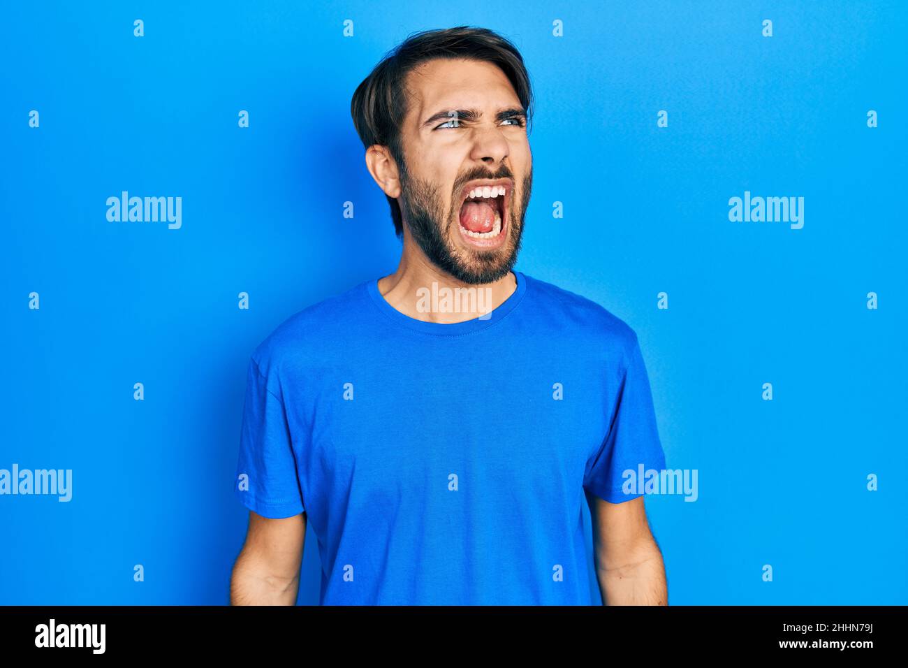 Young hispanic man wearing casual clothes angry and mad screaming ...