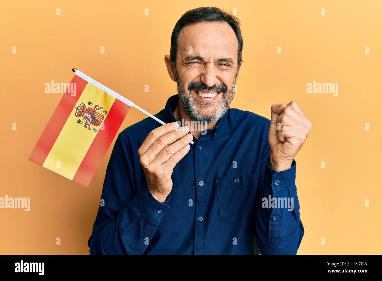Middle age hispanic man holding spain flag screaming proud, celebrating ...
