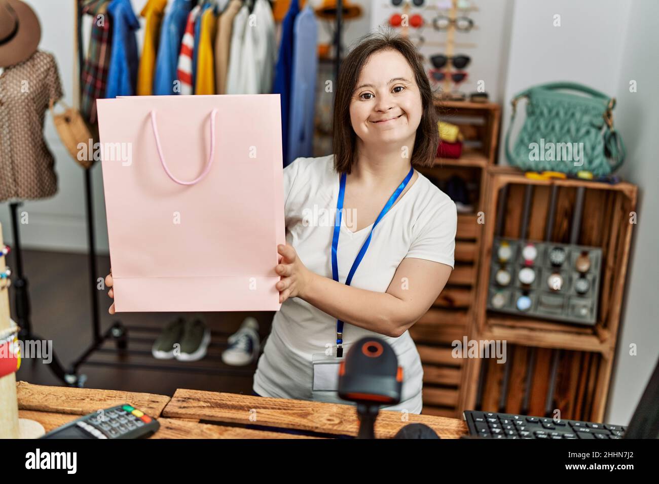Brunette woman with down syndrome working as shop assistant holding ...