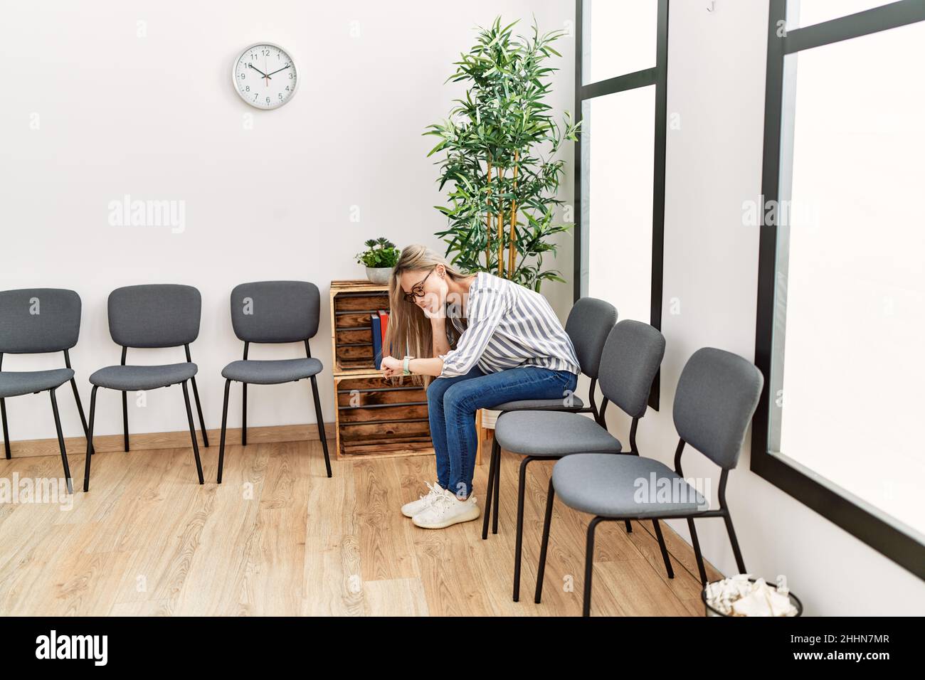 Young chinese woman desperate sitting on chair at waiting room Stock ...
