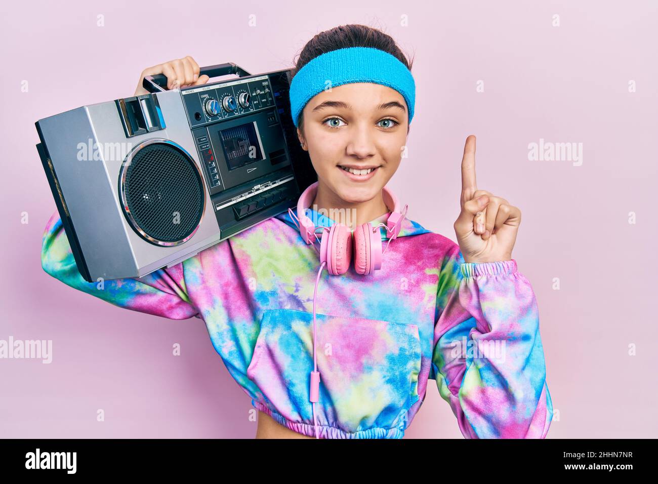 Young brunette girl wearing workout clothes and holding boombox smiling ...