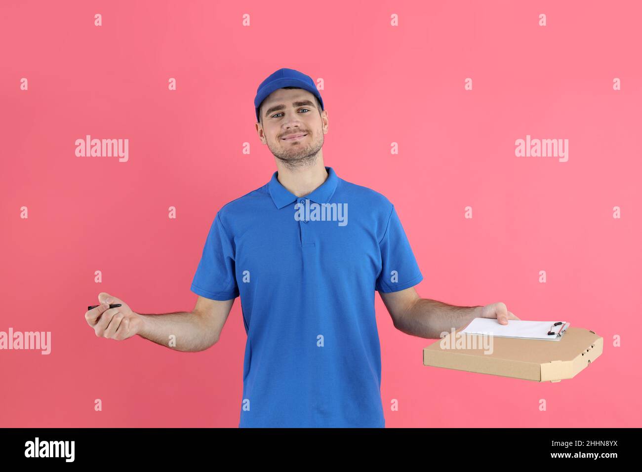 Delivery man with pizza and clipboard on pink background Stock Photo ...