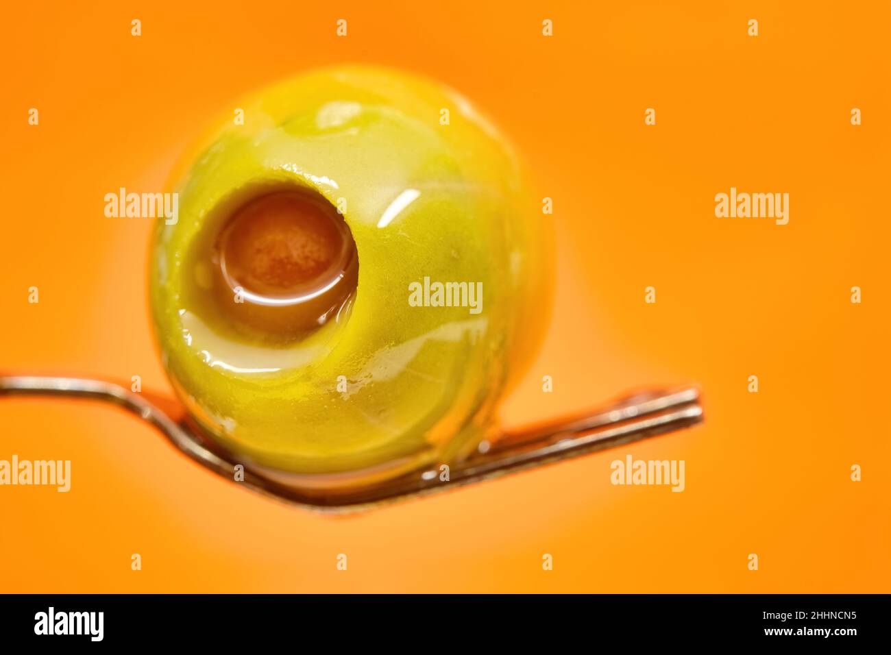 Stuffed olive in orange color background Stock Photo - Alamy