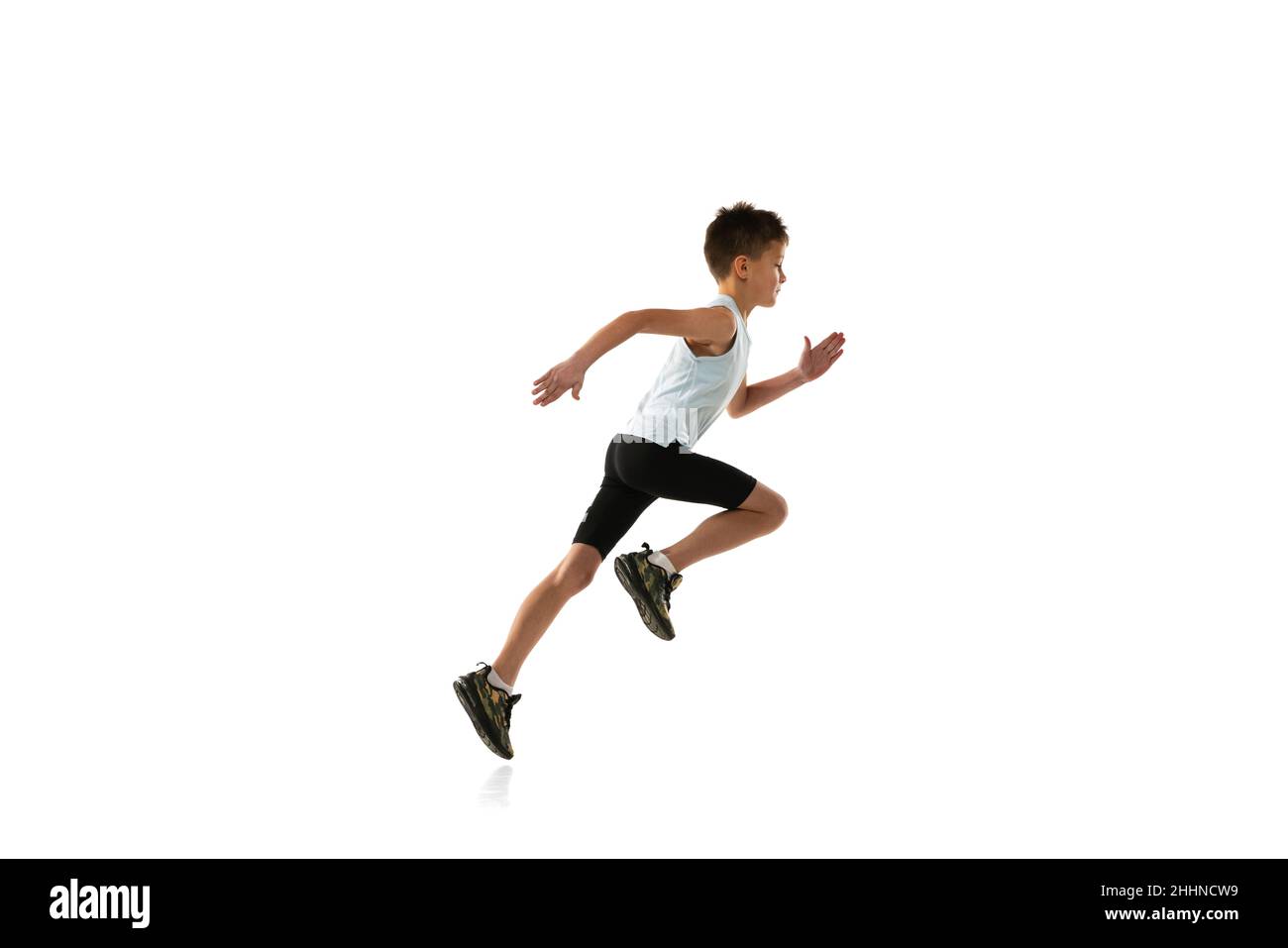 Side view portrait of little boy in motion, running isolated over white ...