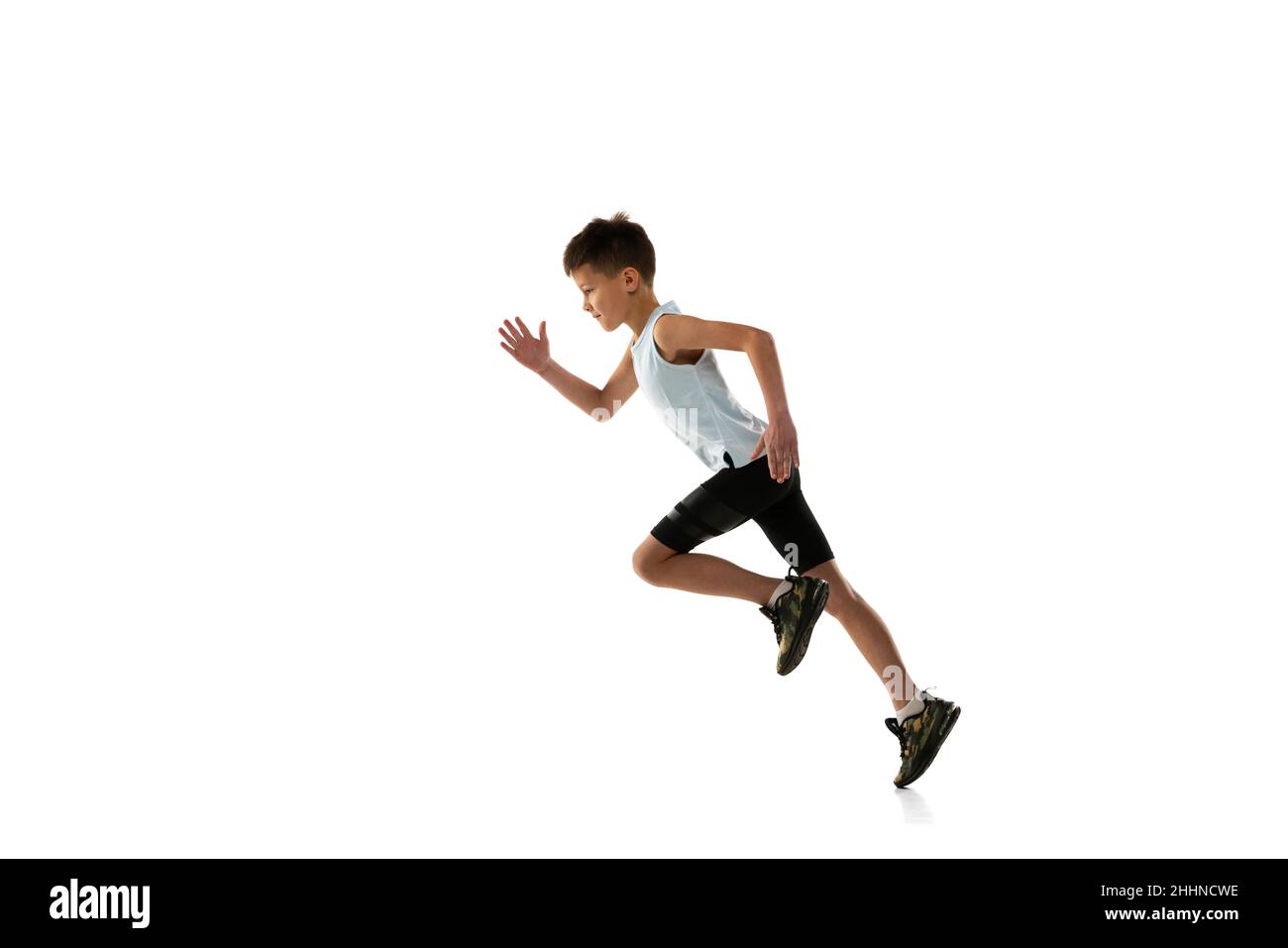 Side view studio portrait of boy, teenager in motion, running isolated ...