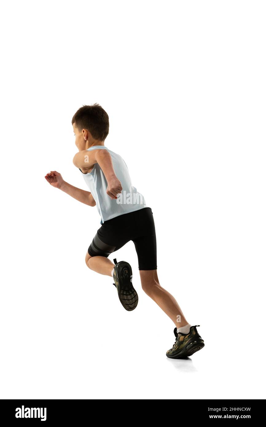 Back view studio shot of little boy, teenager, athlete running ...