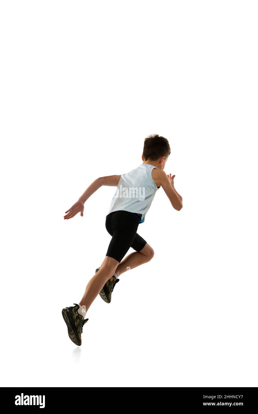 Back view studio shot of little boy, teenager, athlete running ...