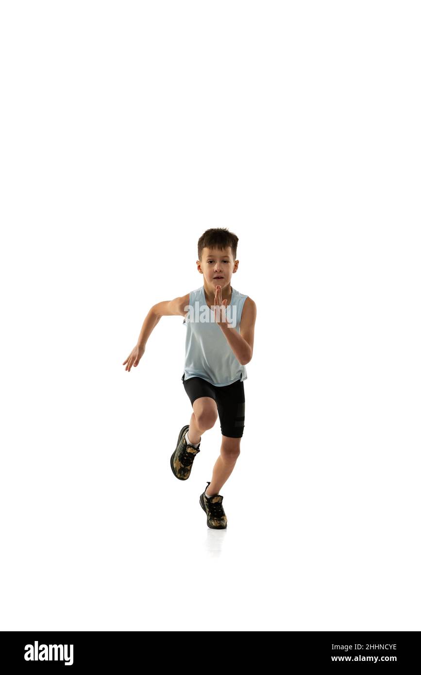 Full-length portrait of little boy, athlete running, training isolated ...