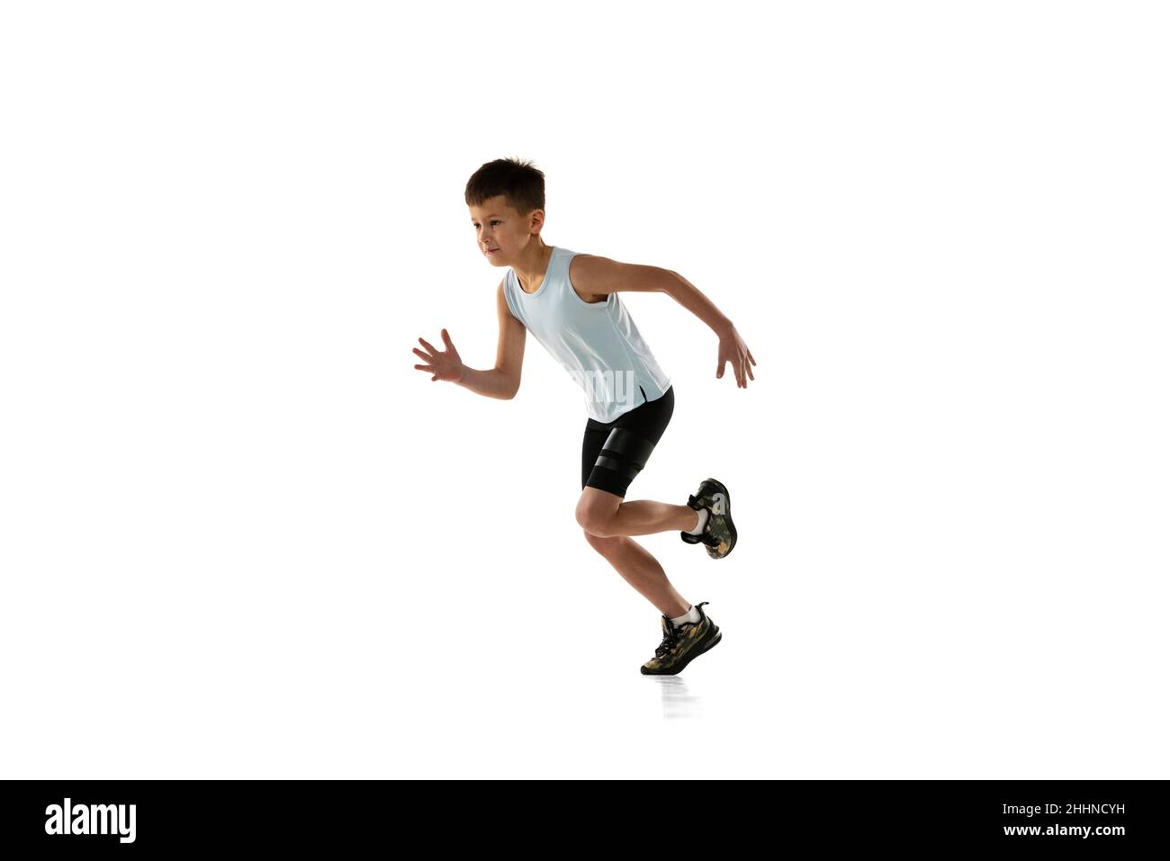 Side view studio portrait of boy, teenager in motion, running isolated ...