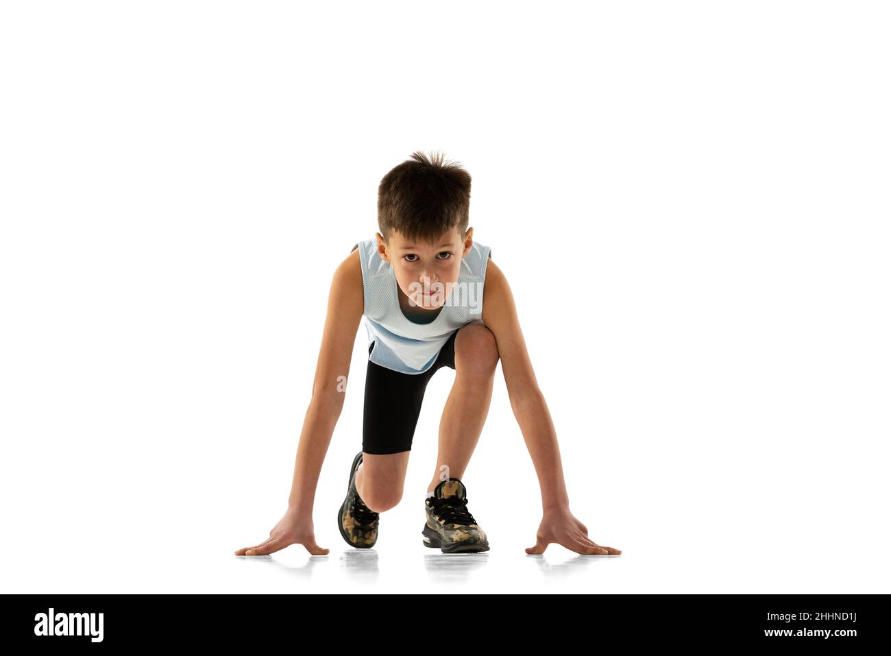 Full-length portrait of boy, child, athlete standing on position to run ...