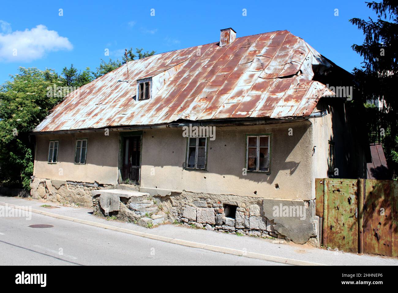 Abandoned small urban family house on broken stone and concrete foundation with damaged facade ...